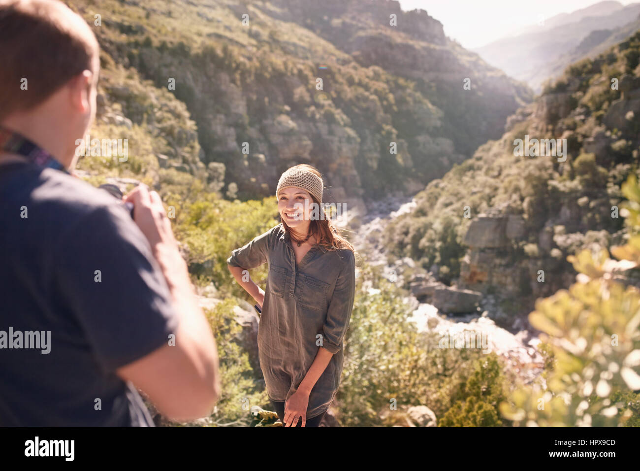 Young man photographing girlfriend at sunny overlook Stock Photo - Alamy