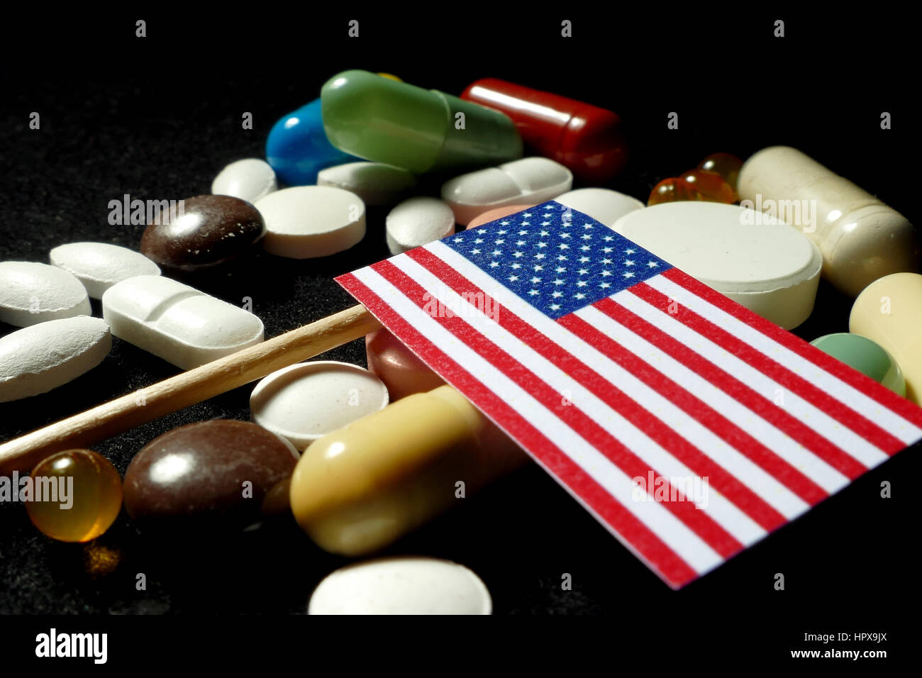 United States flag with lot of medical pills isolated on black ...