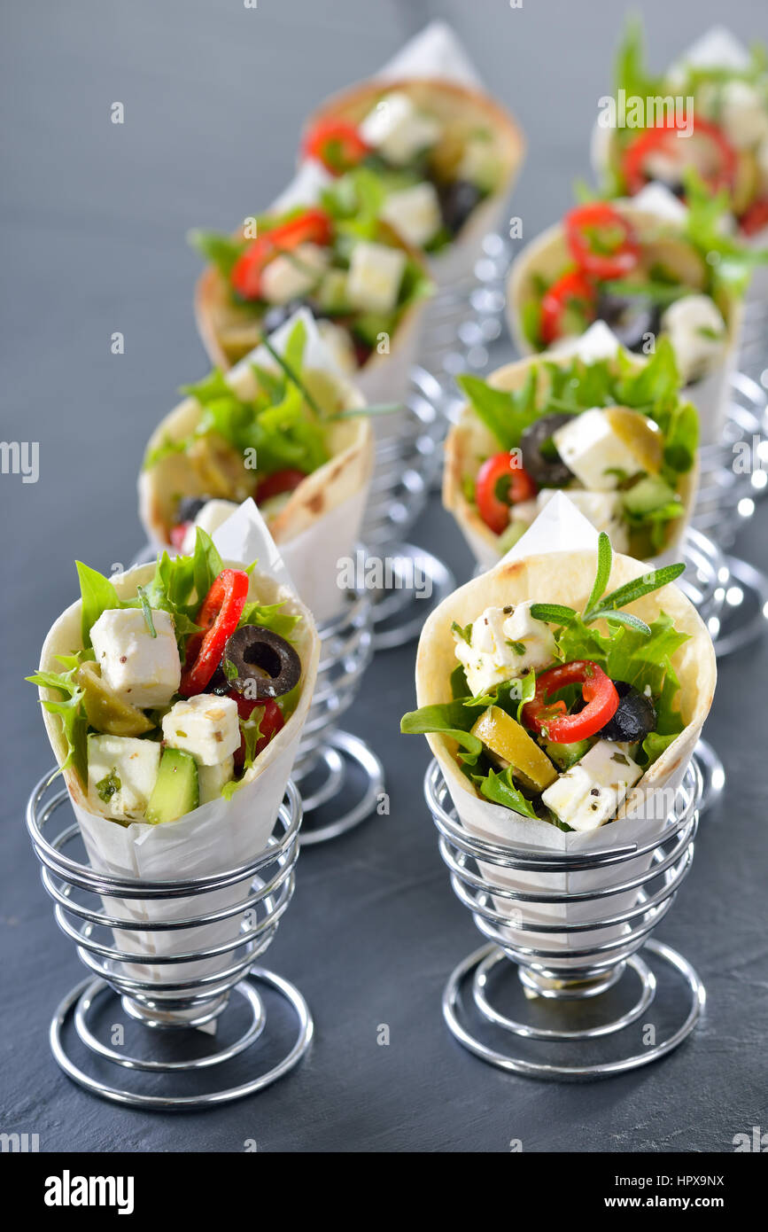 Mini tortillas stuffed with Greek farmers salad with feta cheese and ...
