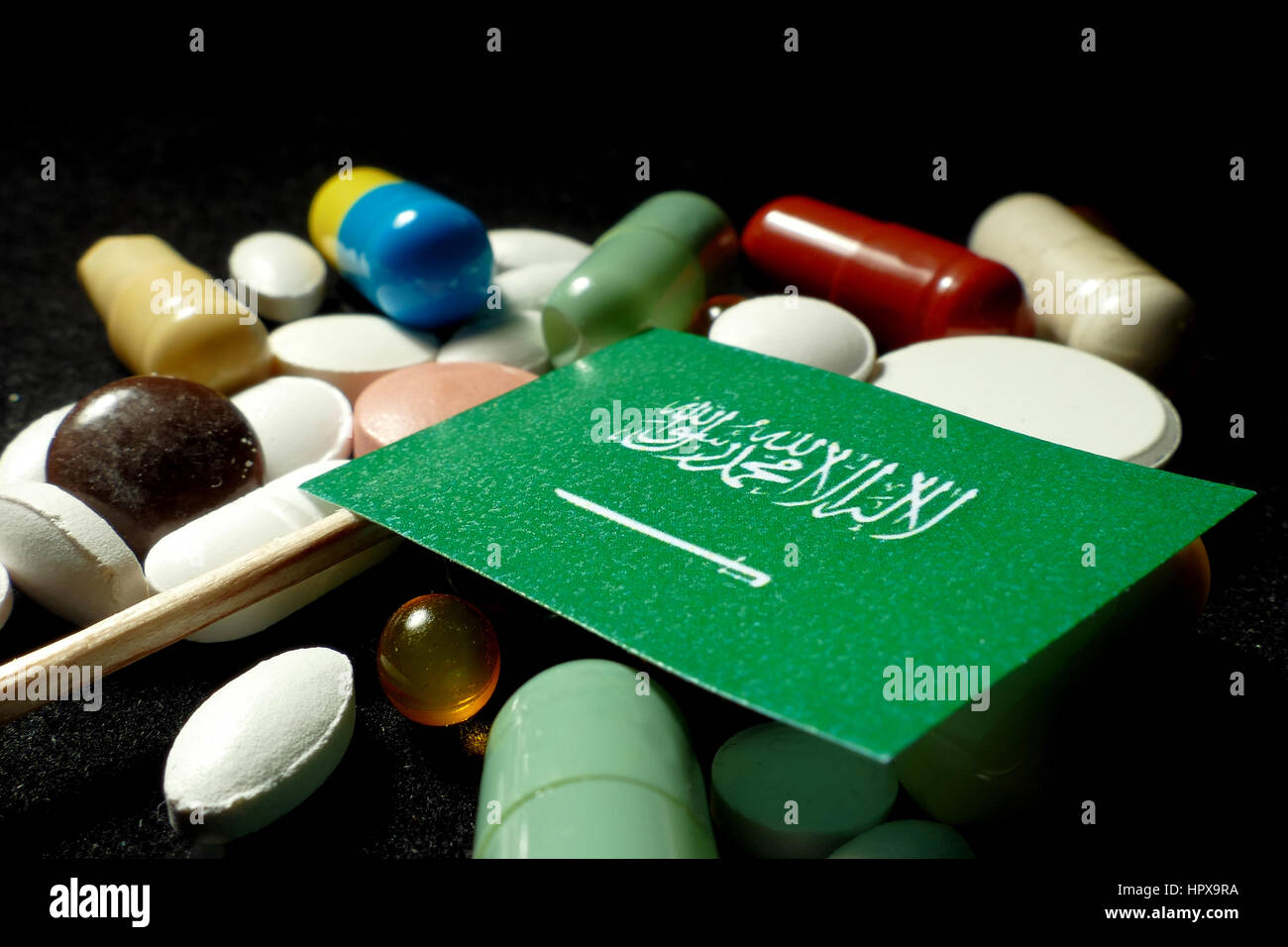 Saudi Arabian flag with lot of medical pills isolated on black ...