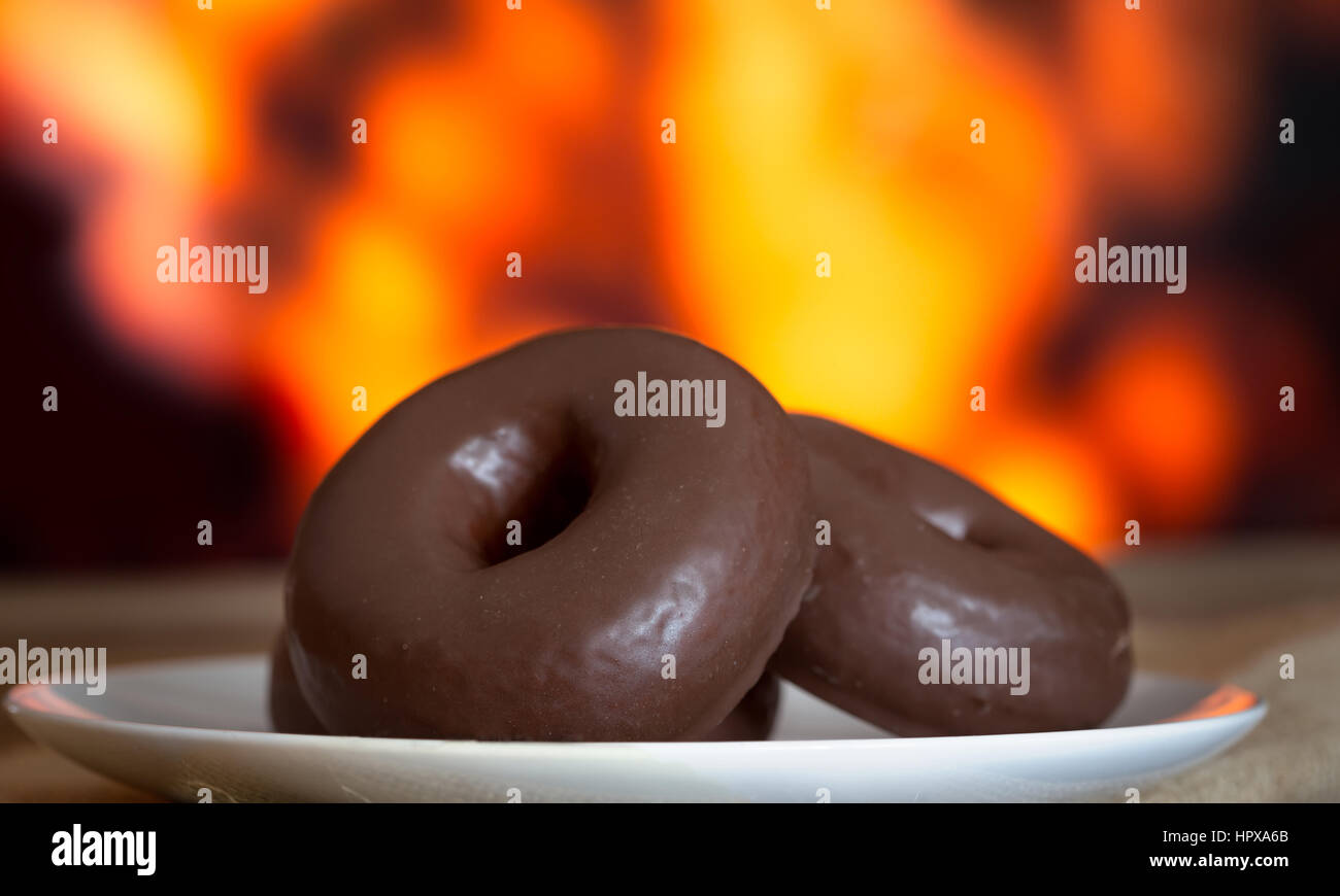 Chocolate donuts with oven fire on background Stock Photo - Alamy