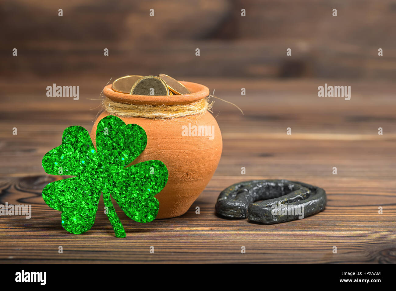 St Patricks day decoration with pot of gold coins, horseshoe and light ...