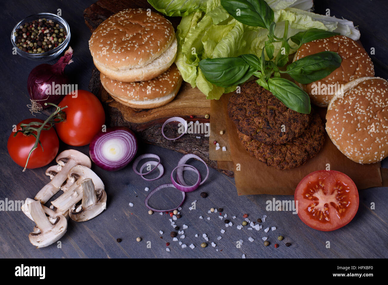 Burger ingredients: beef patties, sesame bun, fresh vegetables, pepper ...