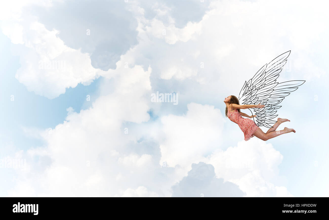 Young woman flying high in blue sky Stock Photo - Alamy