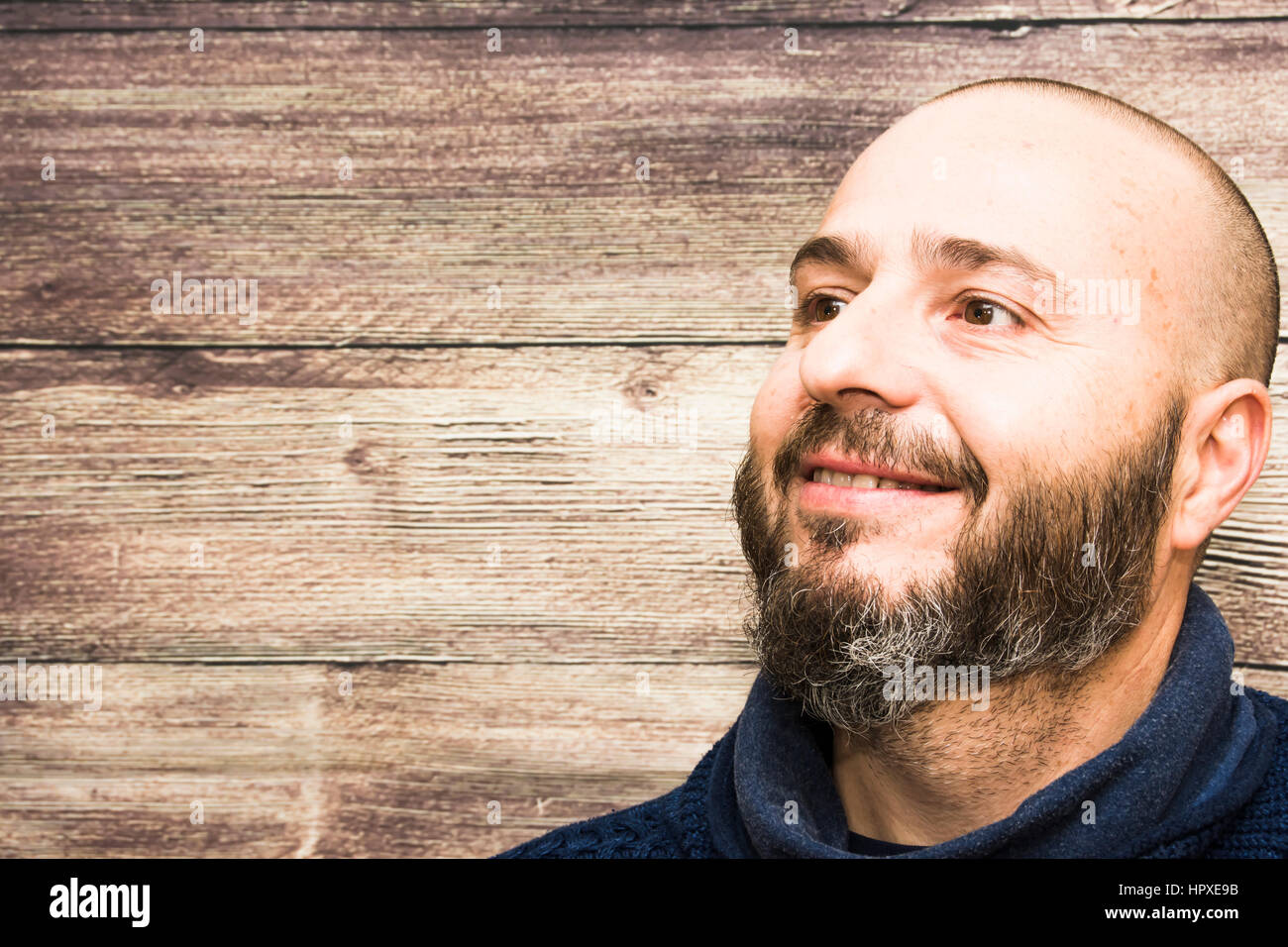 Handsome, bald man with beard on a wooden background Stock Photo - Alamy