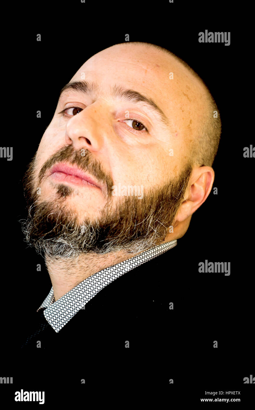 Handsome, bald man with beard, with suit and tie, on black background ...
