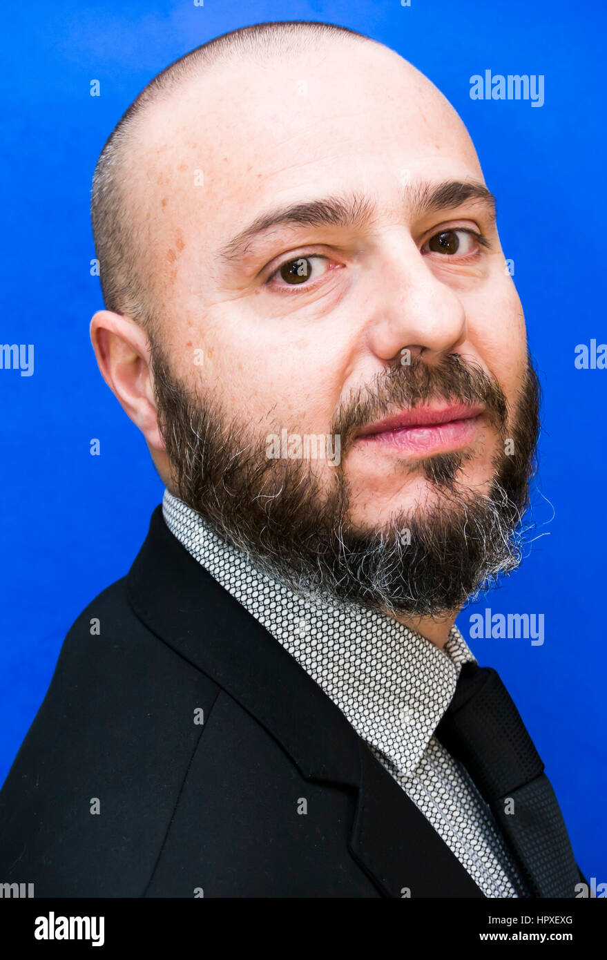 Handsome, bald man with beard, with suit and tie, on blue background ...