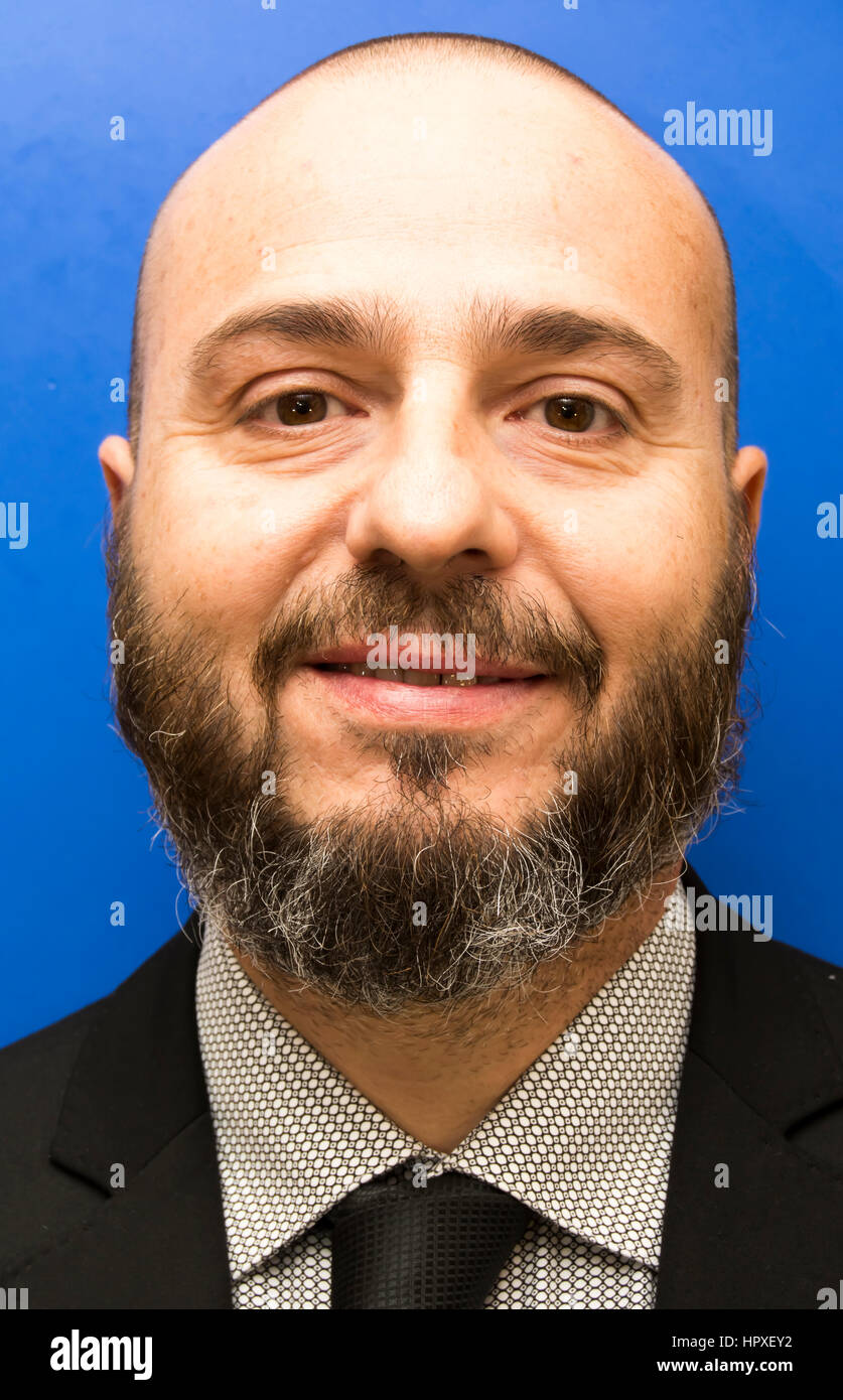 Handsome, bald man with beard, with suit and tie, on blue background ...