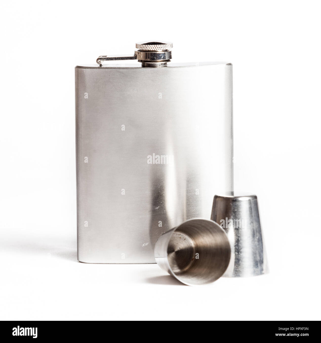 Hip flask and cups isolated on white Stock Photo - Alamy