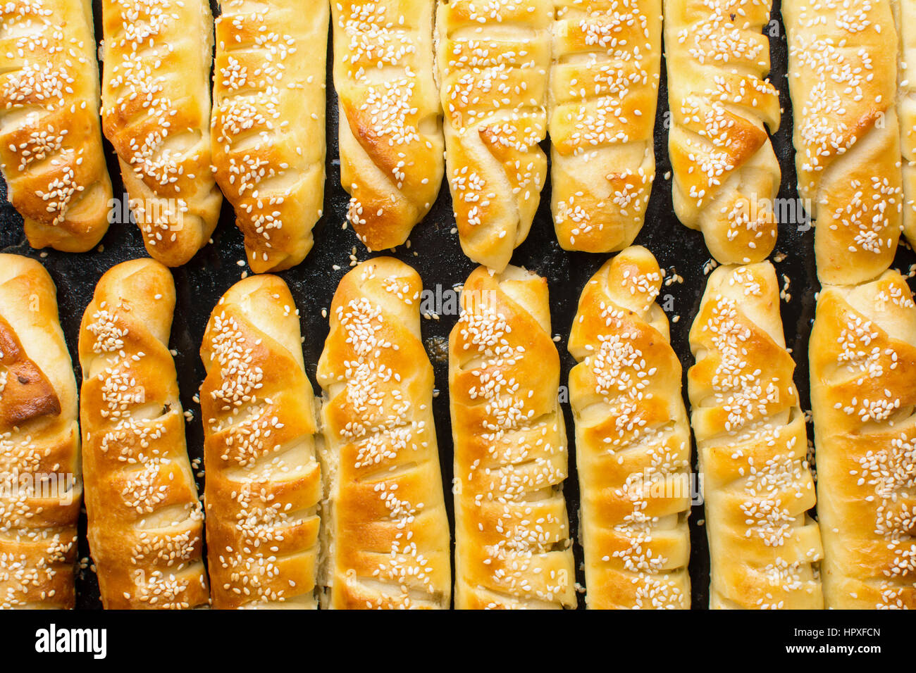 Homemade sesame pastry on black baking pan Stock Photo - Alamy