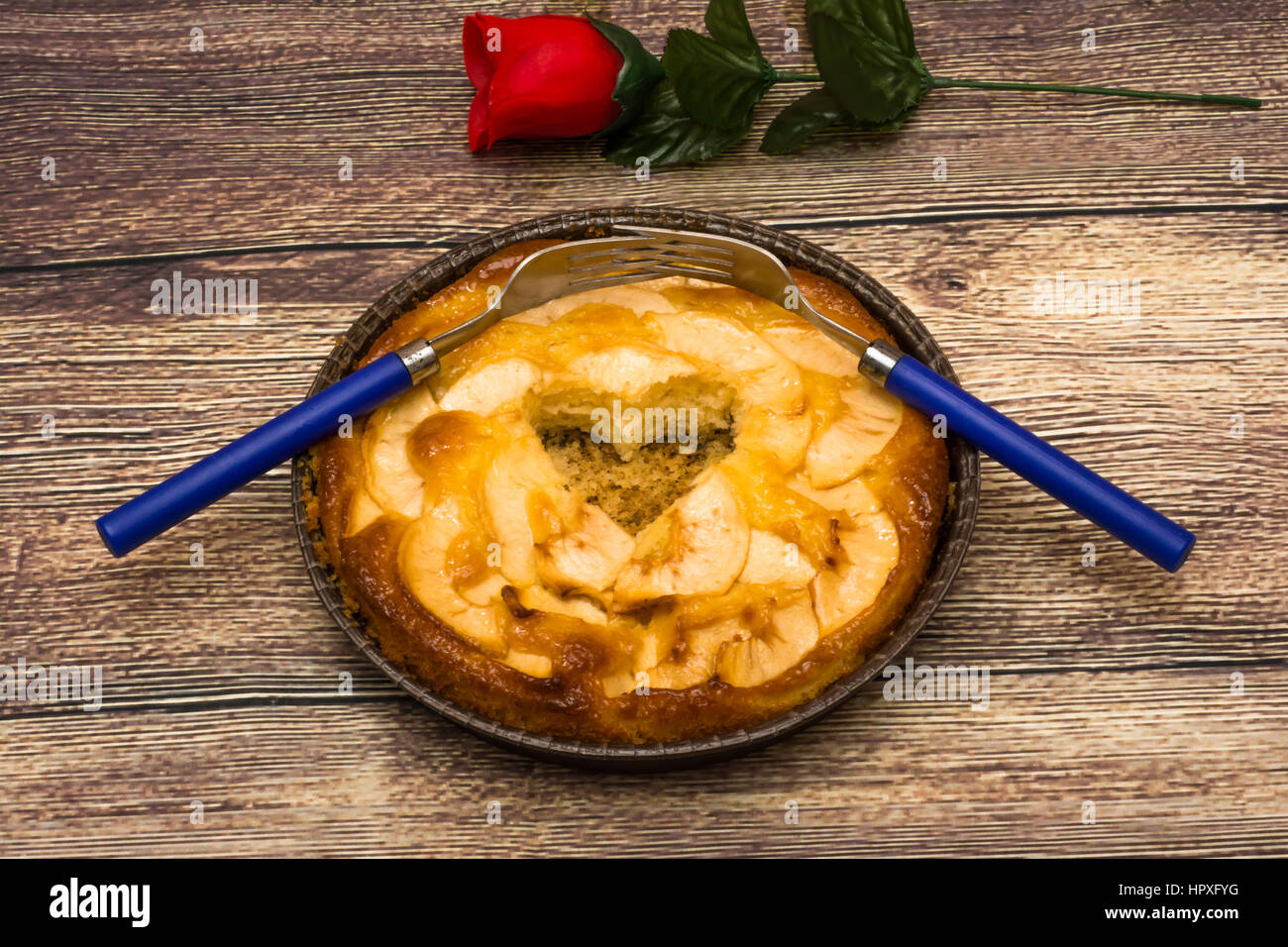 Apple pie with a hollow in the shape of a heart and two forks ...