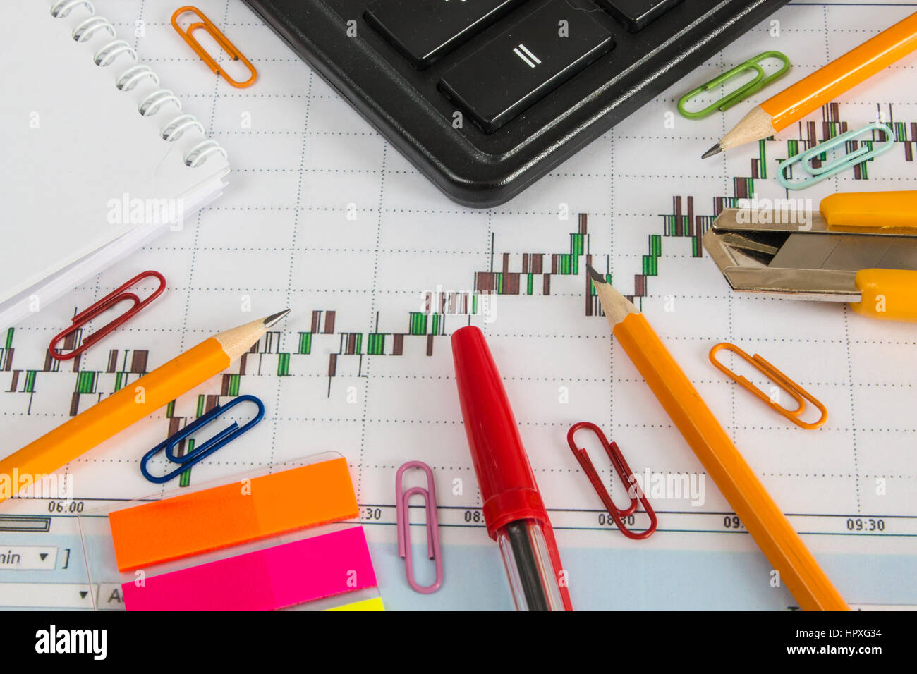 Financial chart on a white background with calculator, coins, pens ...
