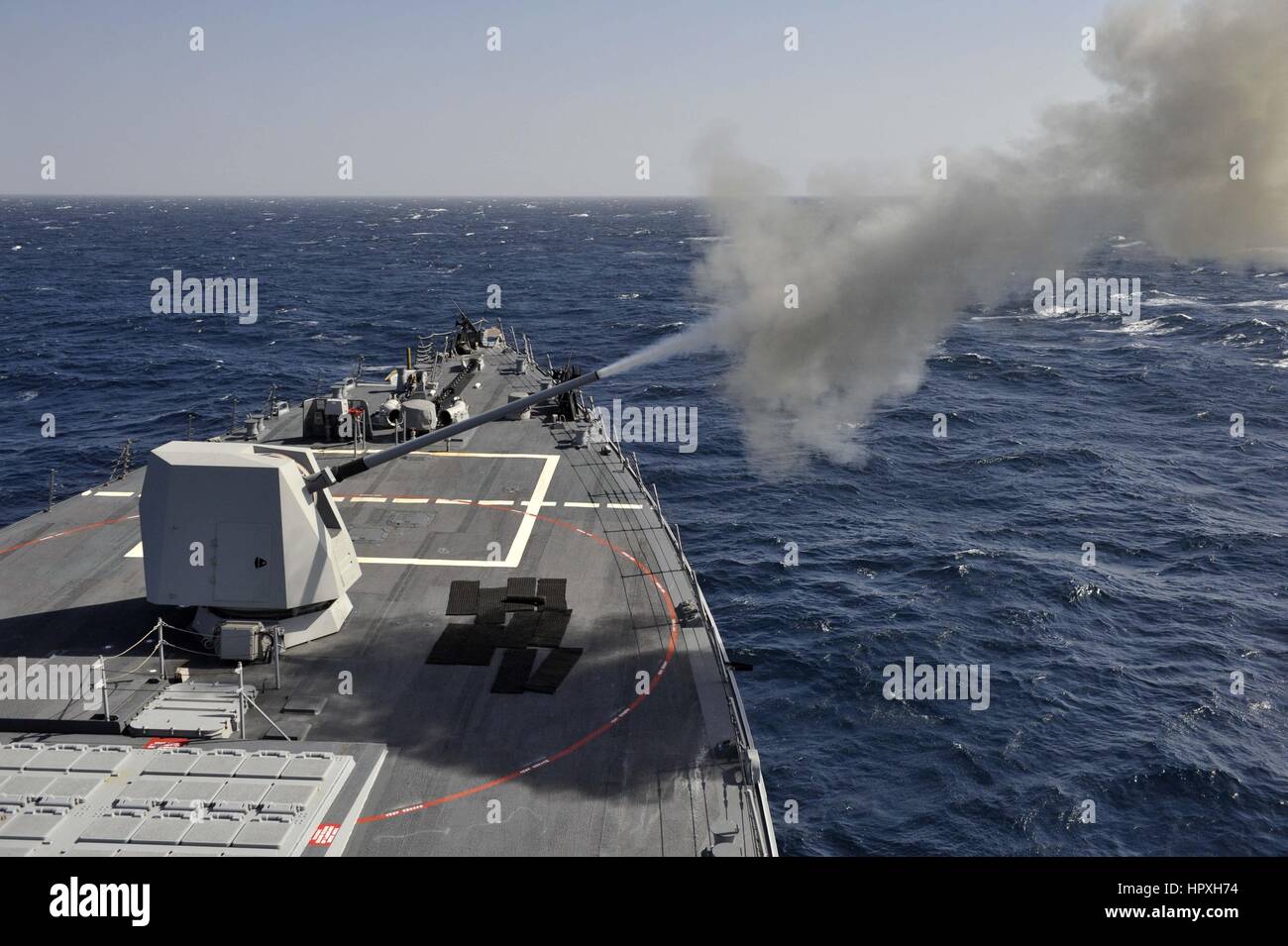 The guided-missile destroyer USS Jason Dunham fires a MK 45 5 inch, 62 ...