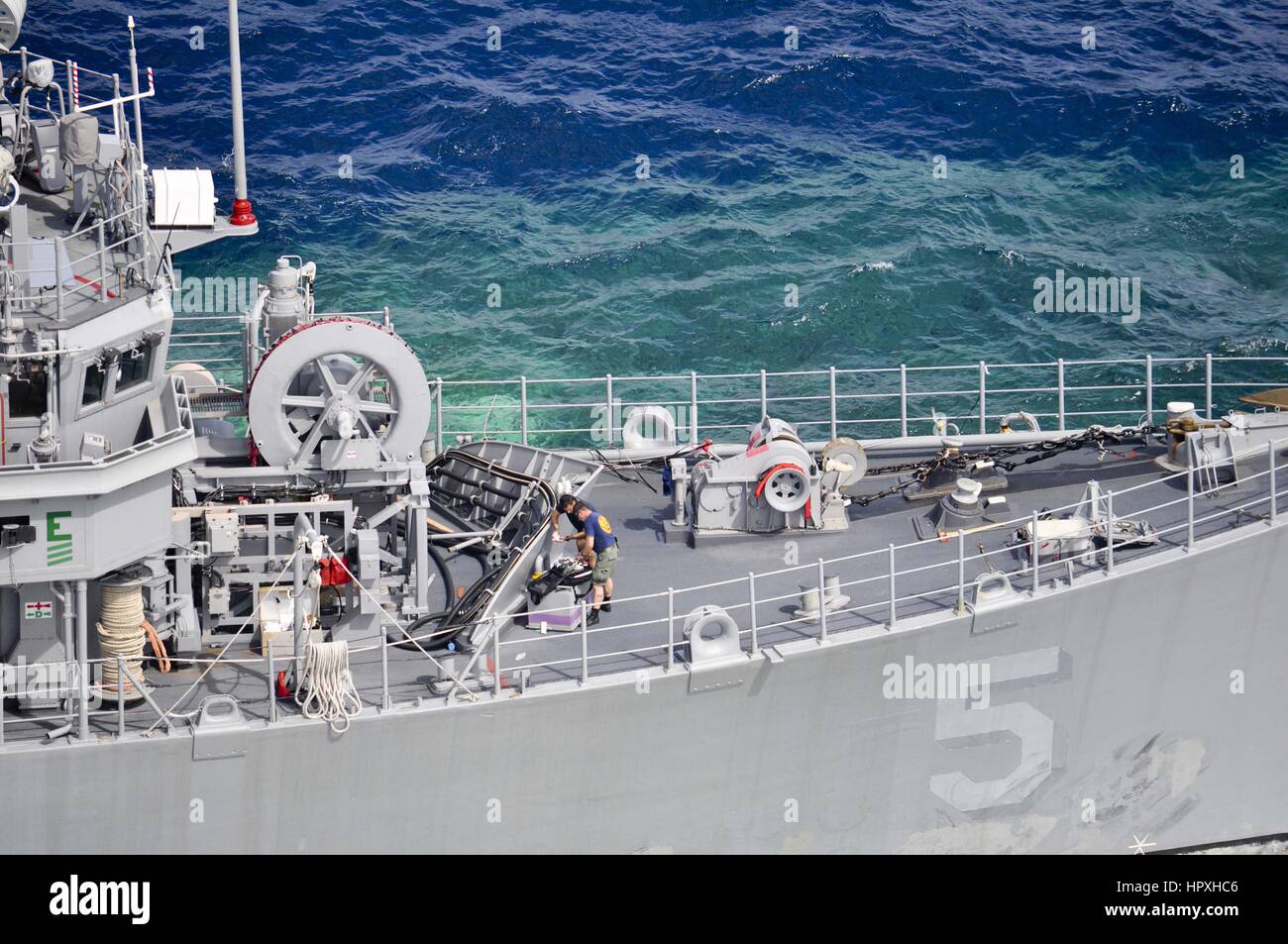 Members of a US Navy salvage assessment team work aboard the mine ...