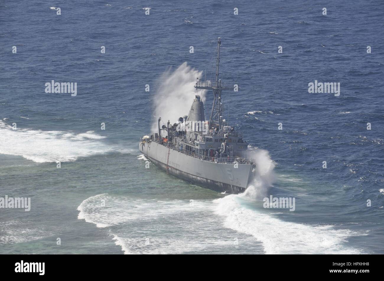 Heavy waves crash against the grounded mine countermeasure ship USS ...
