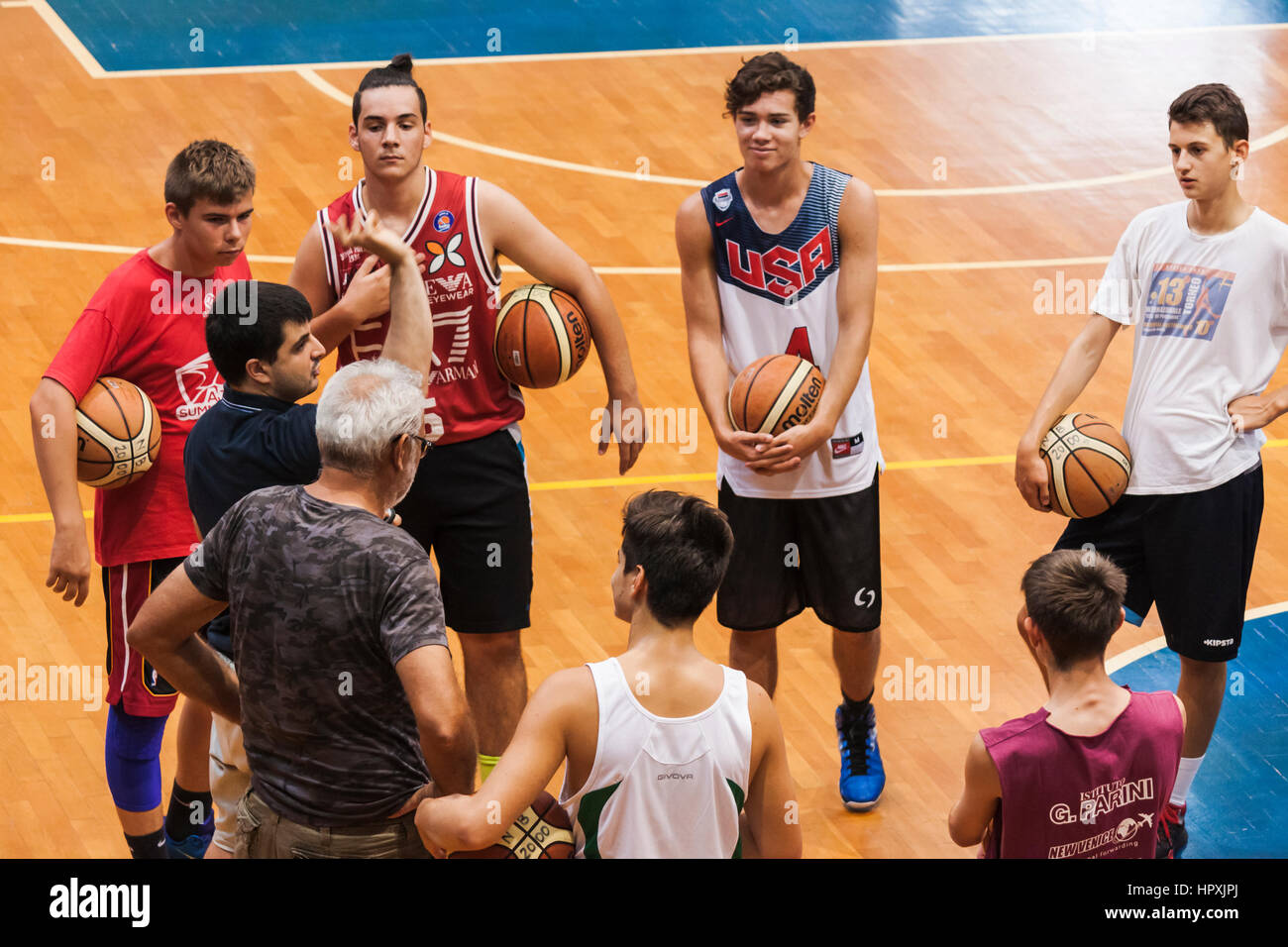 Basketball team listening to the teacher while he is giving ...