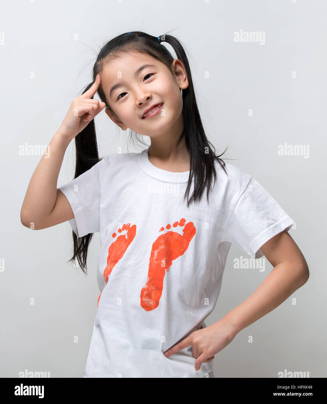 Smiling happy asian girl thinking Stock Photo - Alamy