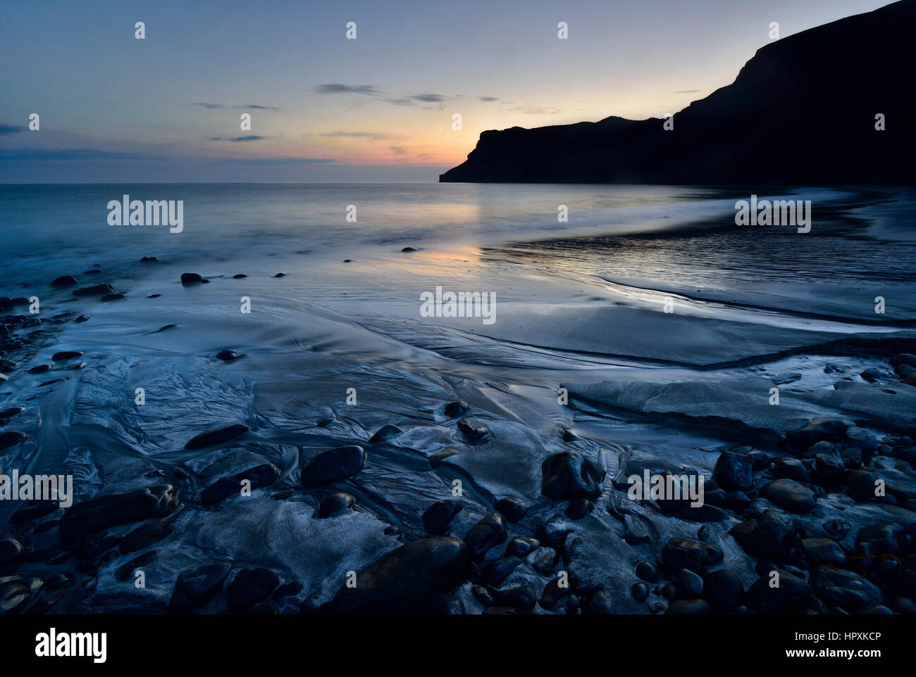 Stones in the sand on the beach of Talisker Bay, Cliff, Isle of Skye ...