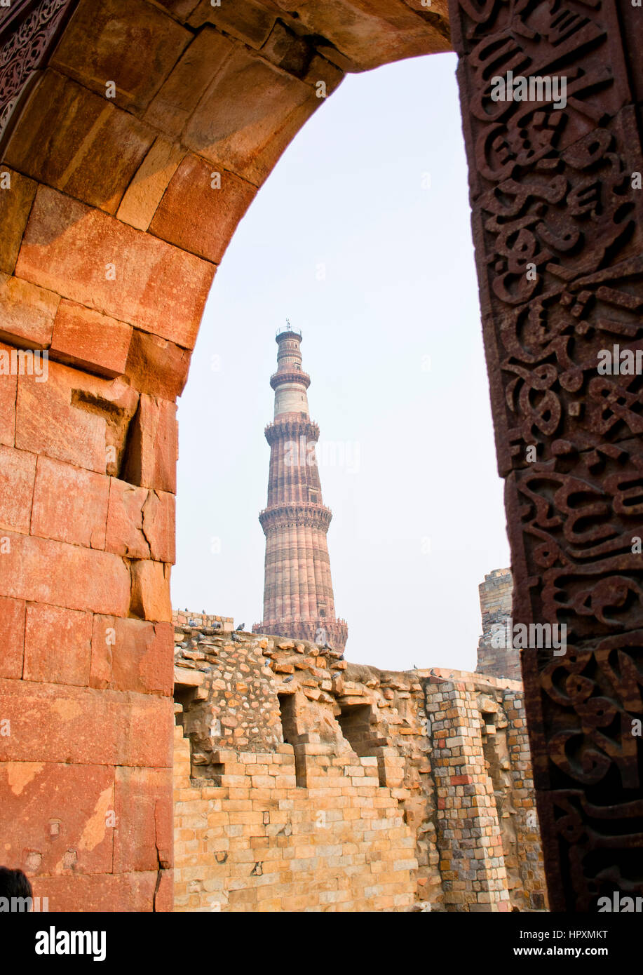 The Qutub Minar minaret, viewed through an arch, in the Qutb Minar ...