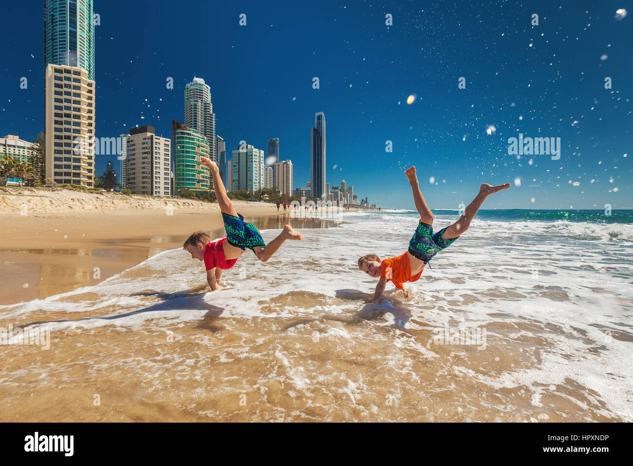 Two young happy boys doing hand stands on Gold Coast beach, Australia ... Two young happy boys doing hand stands on Gold Coast beach, Australia ...