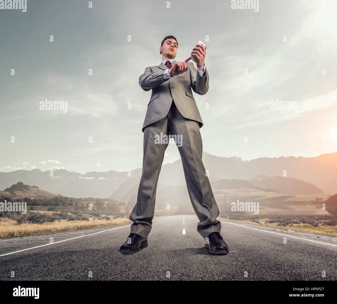 Giant businessman with long legs standing on road Stock Photo - Alamy