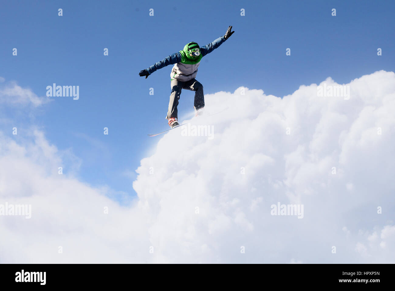Snowboard rider jumping against blue cloudy sky Stock Photo - Alamy