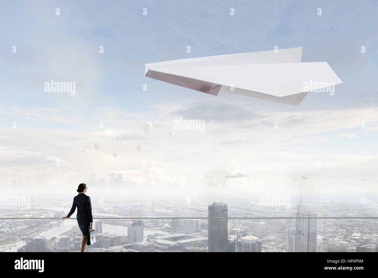 Elegant businesswoman and big paper plane flying in sky. Mixed media ...