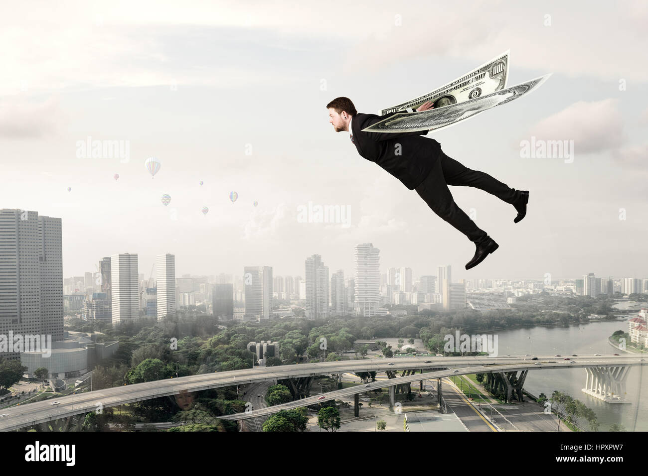 Businessman flying in sky with dollar bills wings Stock Photo - Alamy