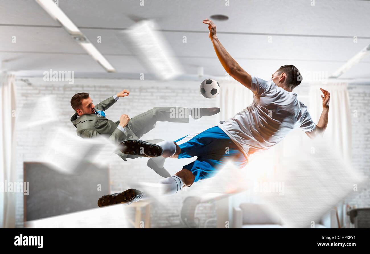 Young elegant businessman and player in office fighting for ball. Mixed ...