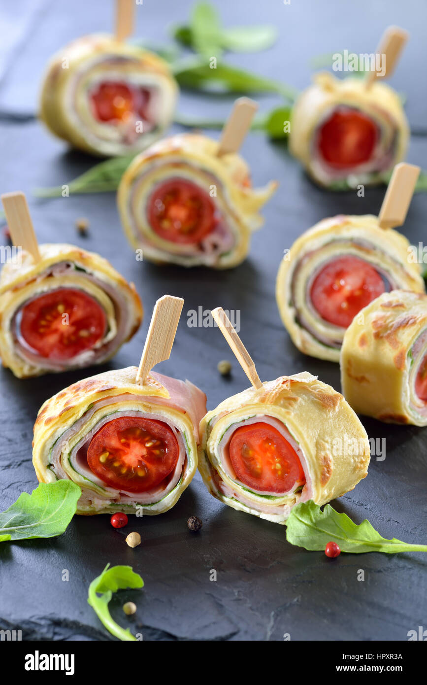 Delicious finger food: Rolls of thin pancakes (crepes) with ham, cream ...