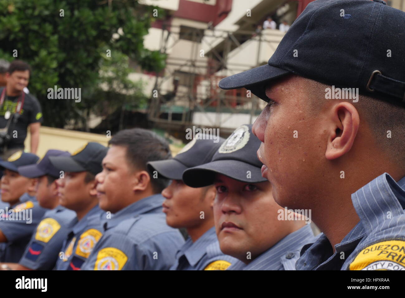 Police officers sweat under the heat of the sun as they try to keep ...