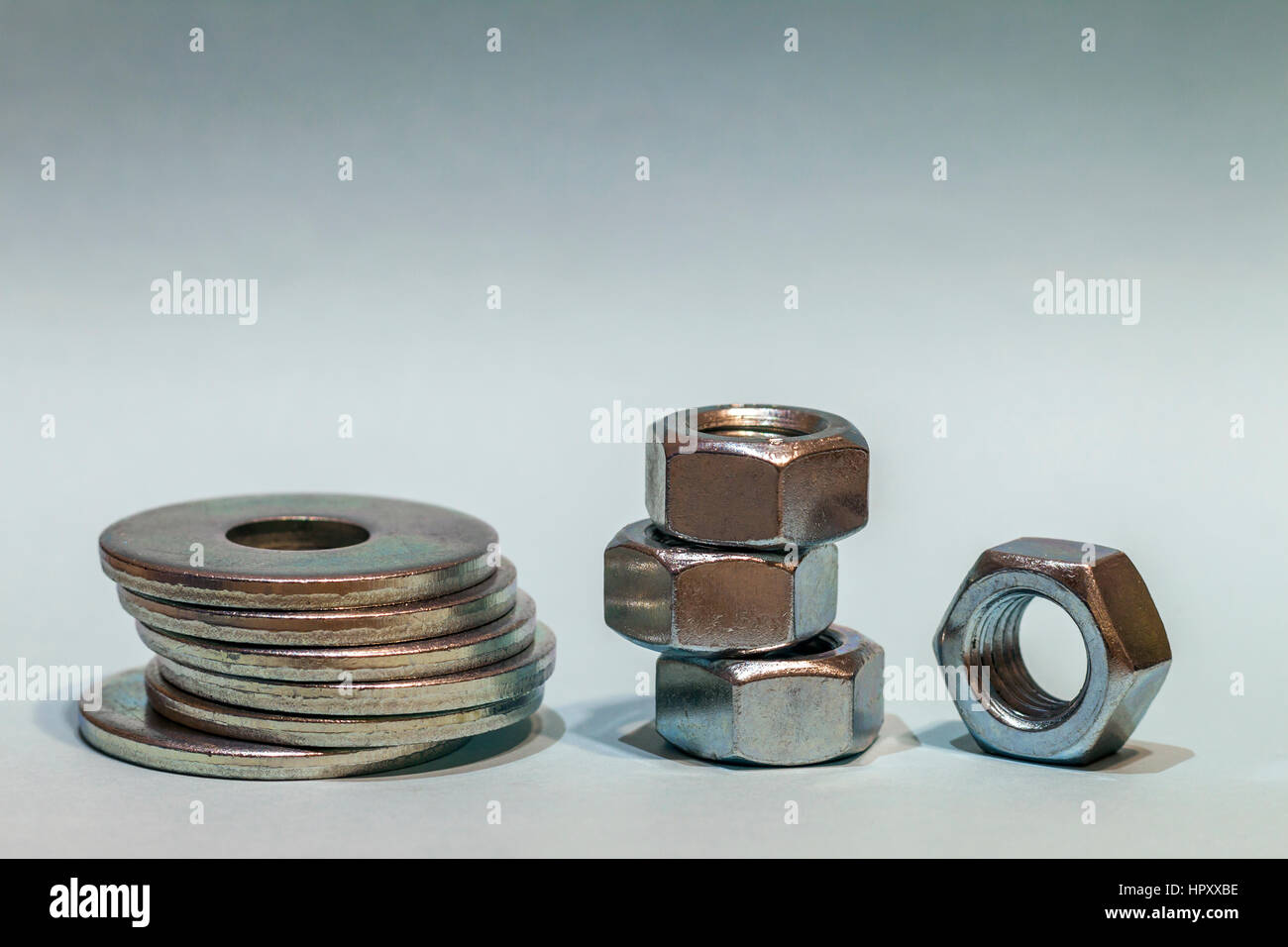 Joiner's accessories. Stacks of metal screw washers and nuts isolated ...