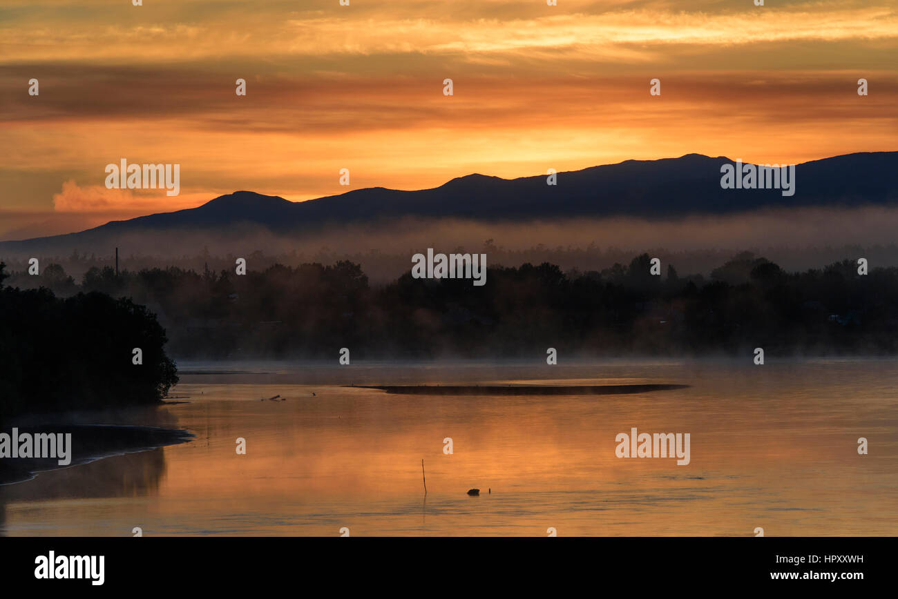 Golden sunrise over a misty Kamchatka river near Kozyrevsk Stock Photo ...