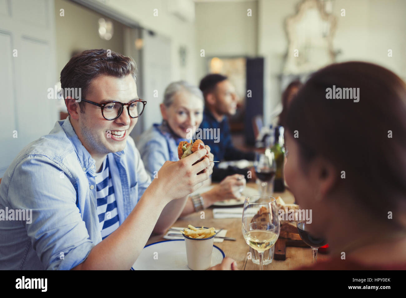 Friends talking and eating at restaurant table Stock Photo - Alamy
