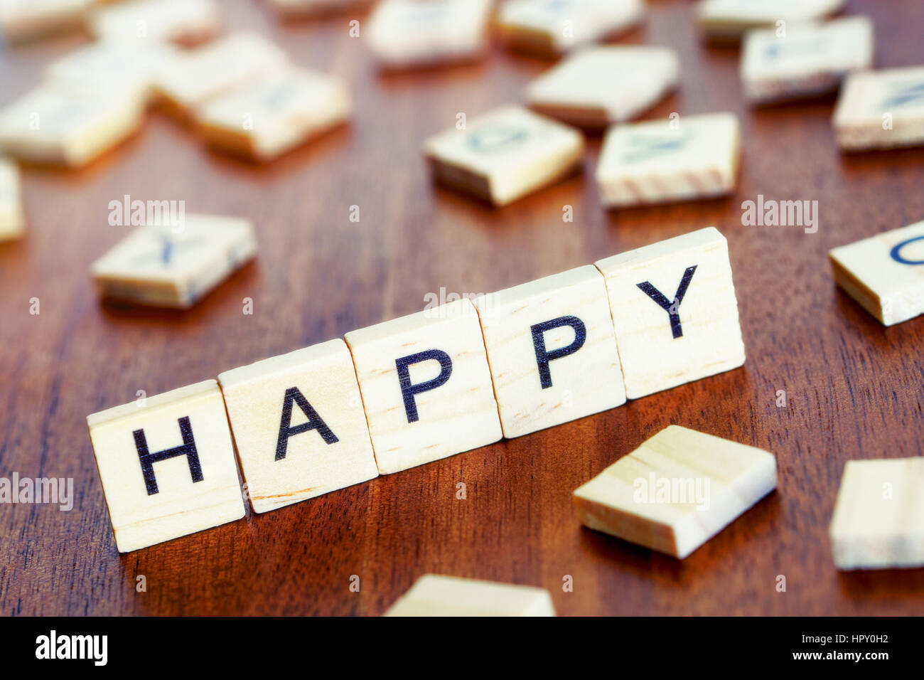 happy word on block concept, letters placed on a desk in precious wood ...