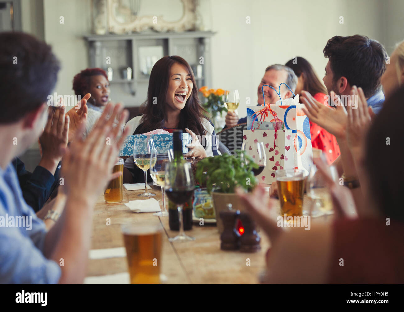 Friends clapping for happy woman celebrating birthday at restaurant ...