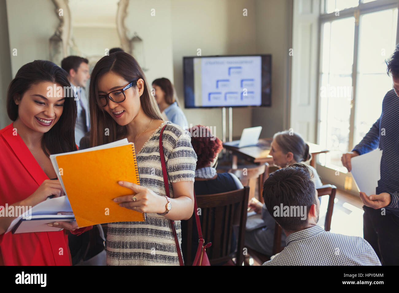 Businesswomen comparing notes at business conference Stock Photo - Alamy