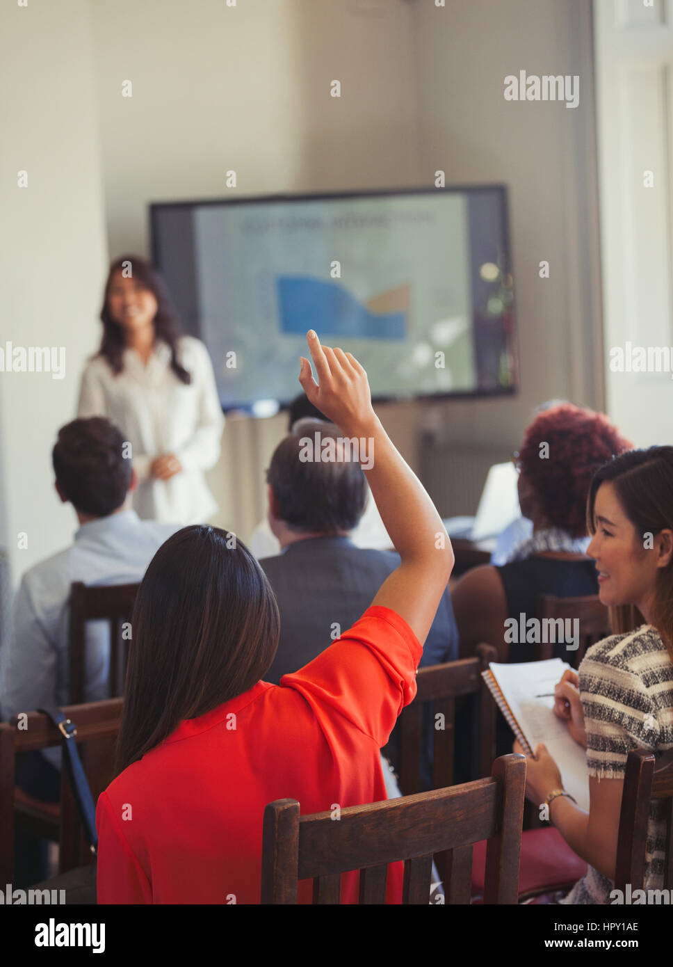 Businesswoman in audience asking question at business conference Stock ...