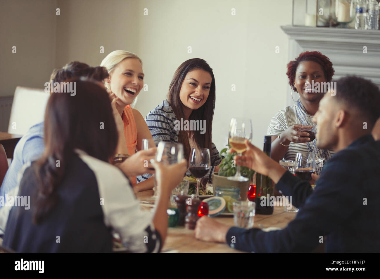 Friends drinking wine and talking at restaurant table Stock Photo - Alamy