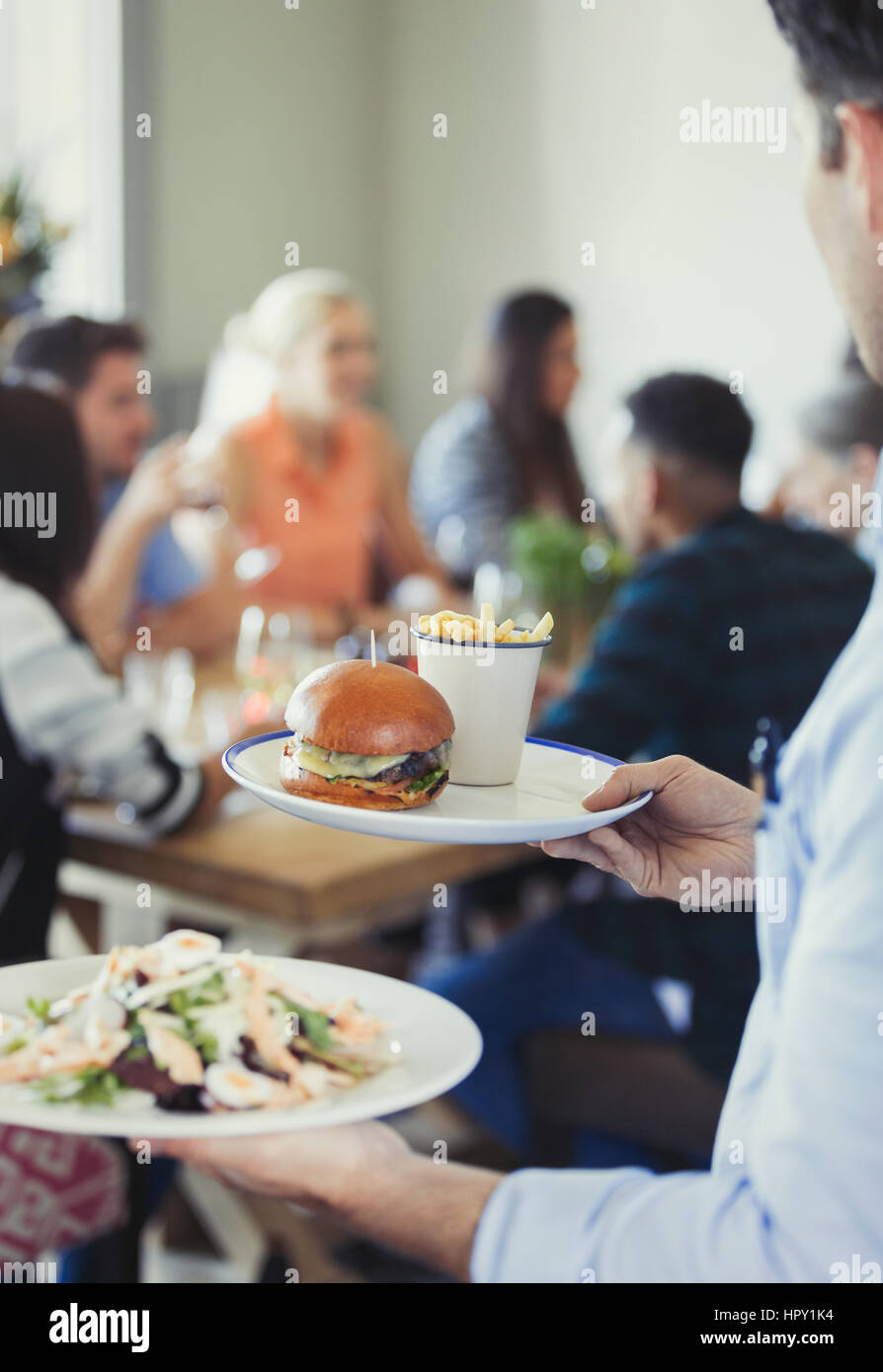 Waiter serving food in restaurant Stock Photo - Alamy