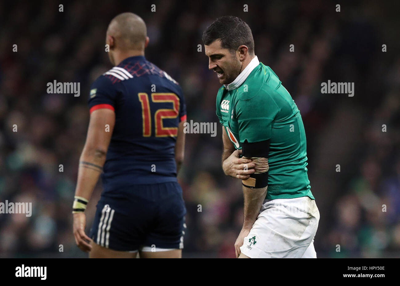 Ireland's Rob Kearney holds his arm after a tackle on France's Gael ...