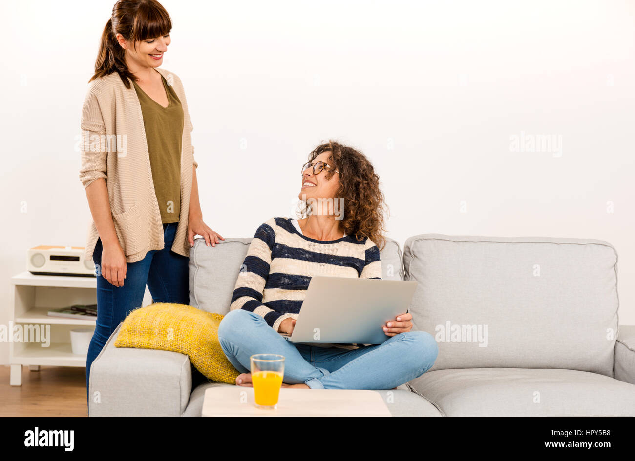 Two beautiful women at home working with a laptop Stock Photo - Alamy