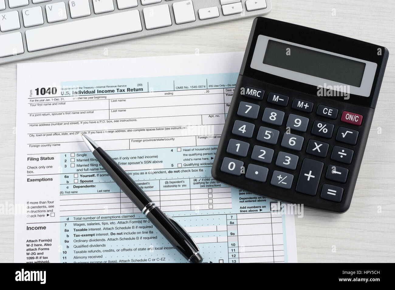 Tax return blank, calculator and pen Stock Photo - Alamy