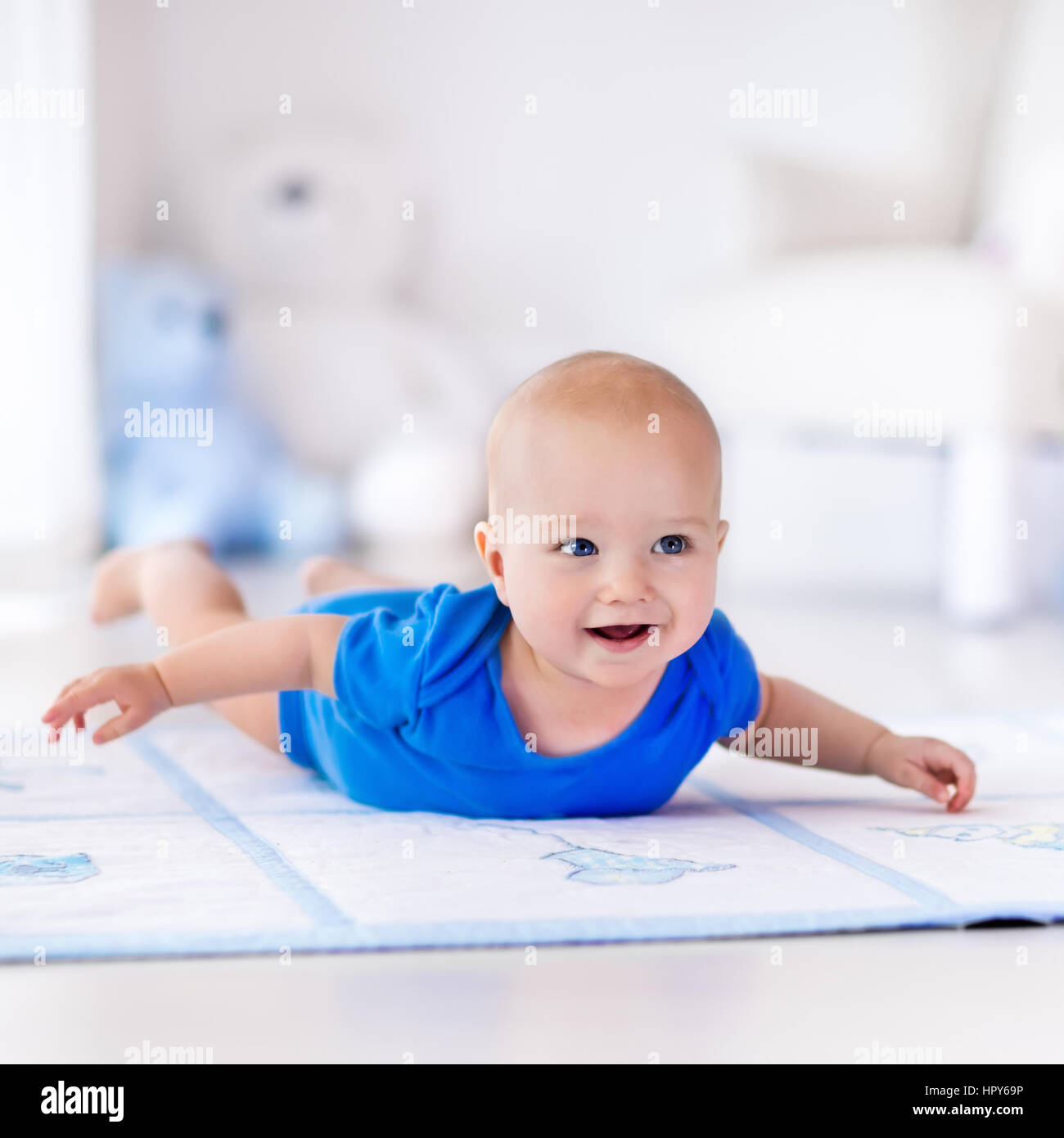 Adorable baby boy learning to crawl and playing with colorful toy in ...