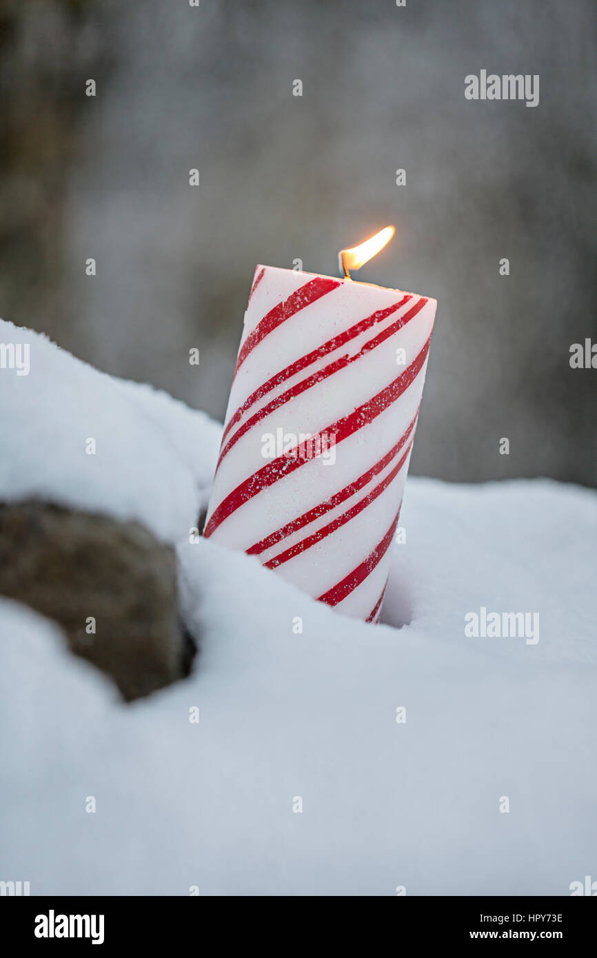 Candle glowing outdoors in snow Stock Photo - Alamy