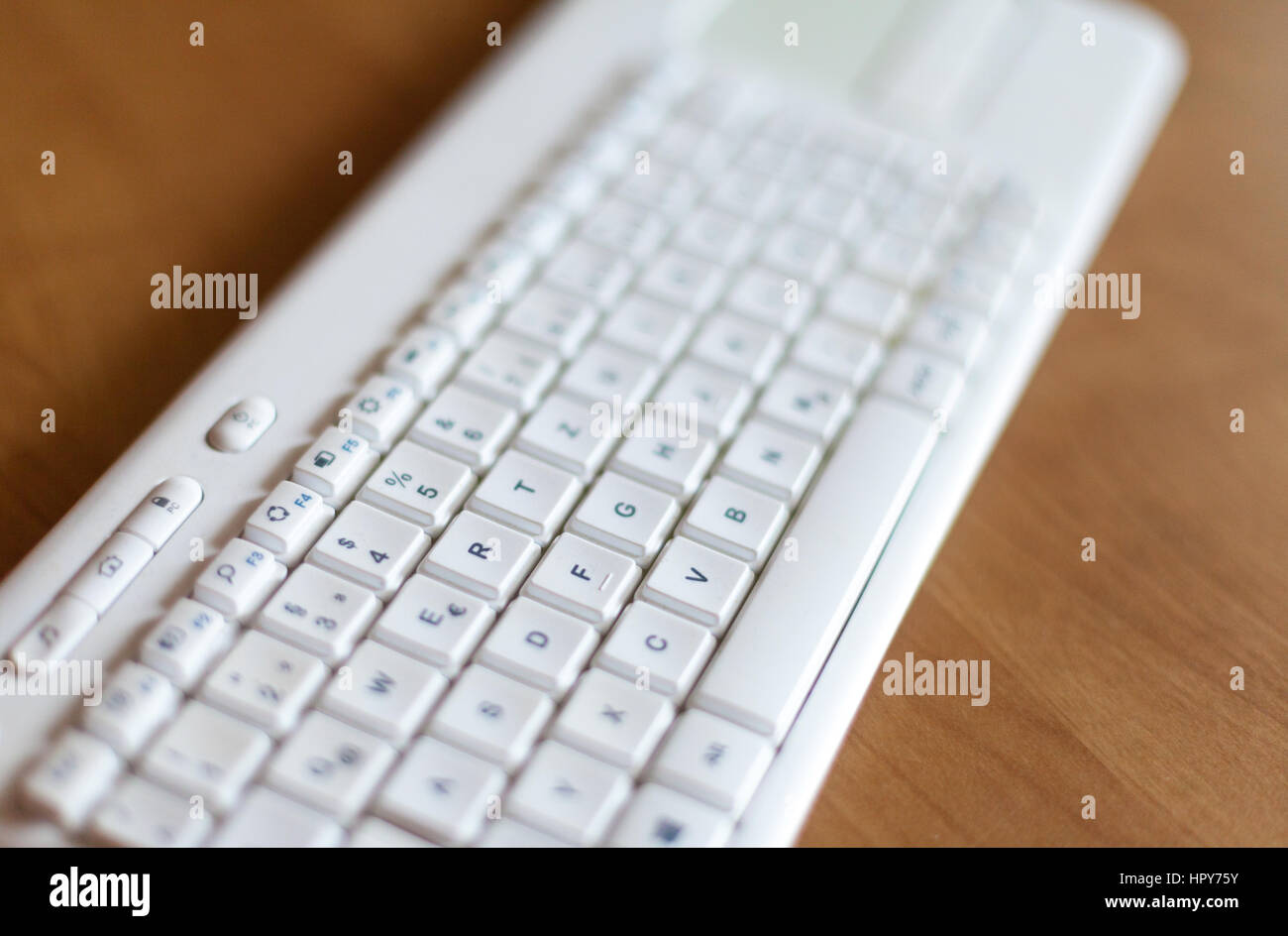 white keyboard lies on brown wood texture Stock Photo - Alamy