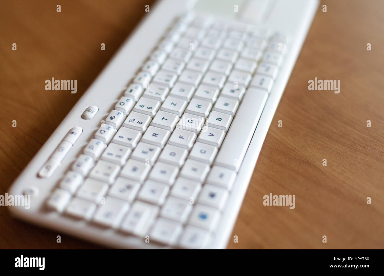white keyboard lies on brown wood texture Stock Photo - Alamy
