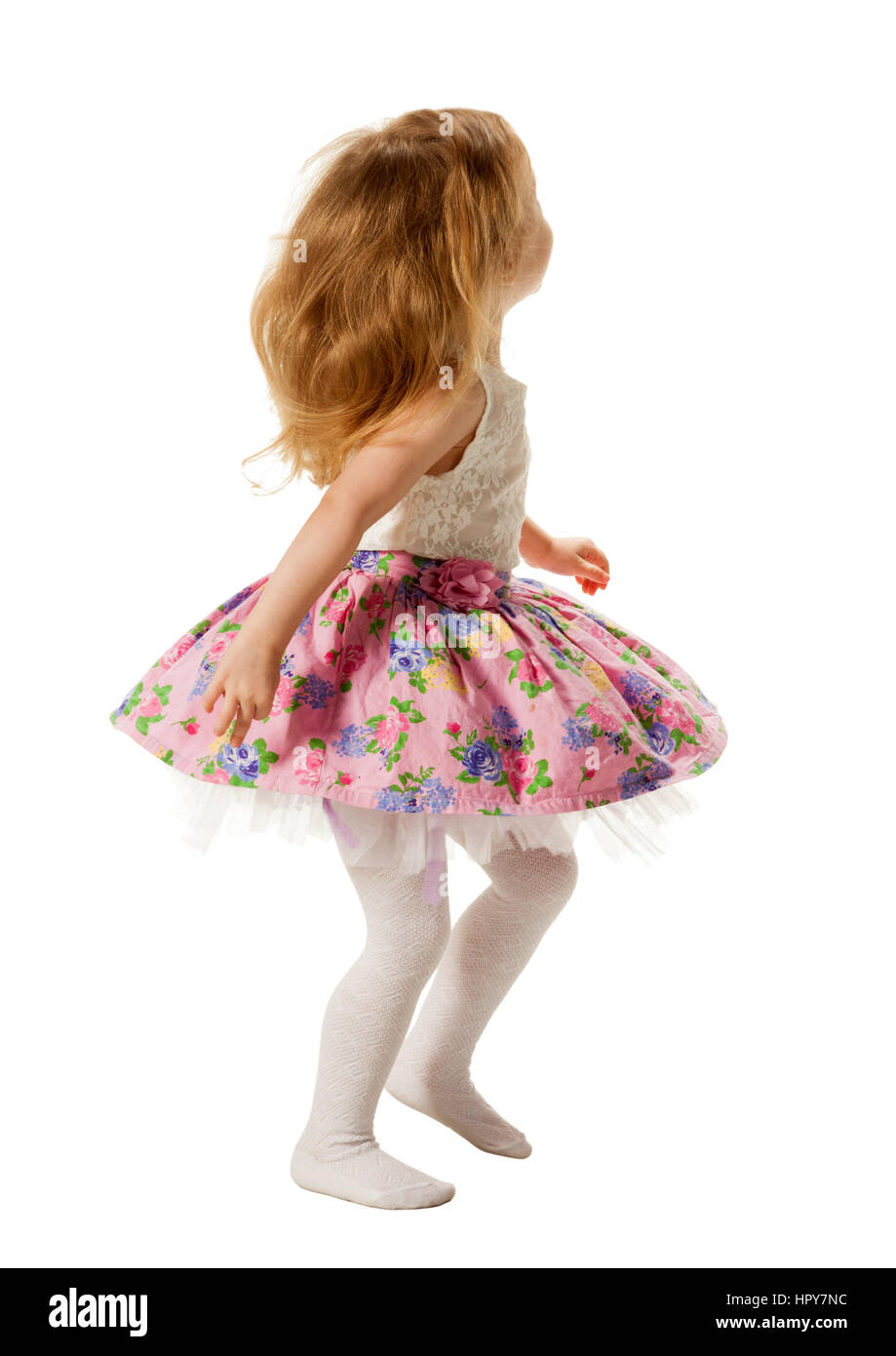 Cute three-year girl is jumping, running, dancing, laughing. Her hair ...