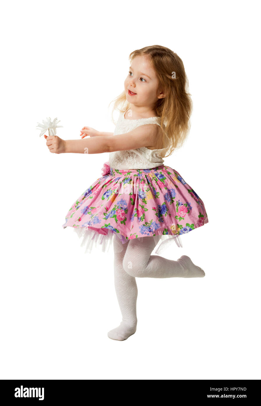 Cute three-year girl is jumping, running, dancing, laughing. Her hair ...