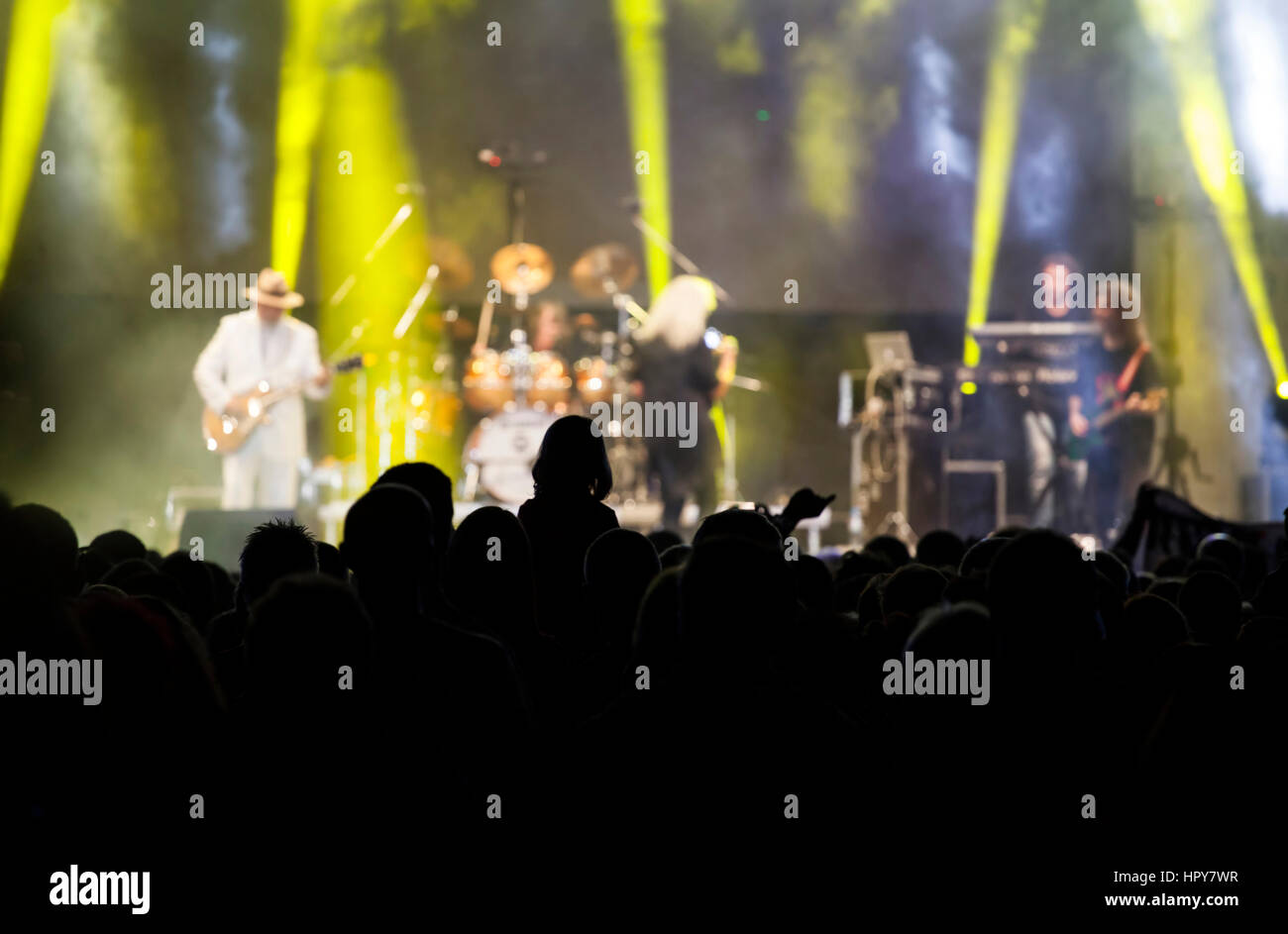 Photo of many people enjoying rock concert, crowd with raised up hands ...